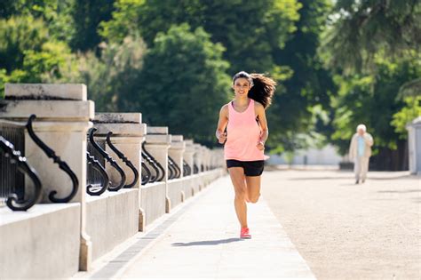 가 스포츠를 실행 하 고 피트 니스와 건강 한 라이프 스타일 개념에 나무와 노란 잎 도시 공원에 야외 운동 조깅에 훈련에서 젊은 매력과 행복 주자 여자 달리기에 대한 스톡