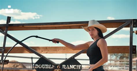 검은색 탱크탑과 파란색 데님 청바지를 입은 여자가 갈색 옆에 서 있는 흰색 카우보이 모자를 쓰고 있다 사진 Unsplash의 무료 여자 이미지