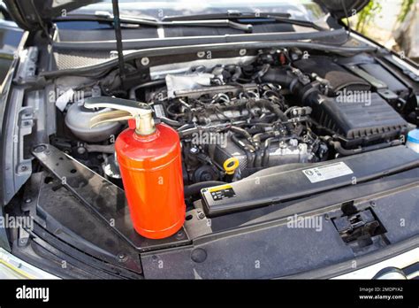 Car Fire Extinguisher On The Background Of The Car Engine Extinguishing Class Of Fire
