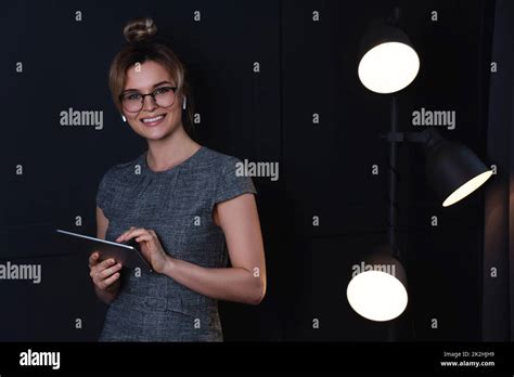 Businesswoman Using Wireless Earbuds And Tablet Pc During Late Night