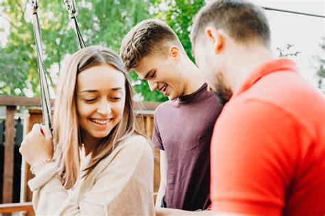 귀여운 젊은 백인 남성은 그의 여자 친구가 웃 고 찾고 있는 동안 밧줄 슬라이드 플랫폼에 장착 되는 동안 점프 하기 전에 웃 고