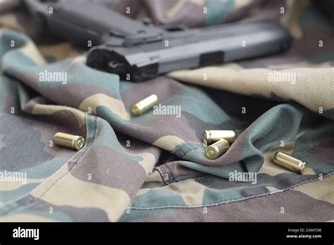9mm Bullets And Pistol Lie On Folded Camouflage Green Fabric A Set