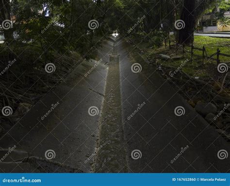 Canalization Of The Medellin River With Light In The Background And