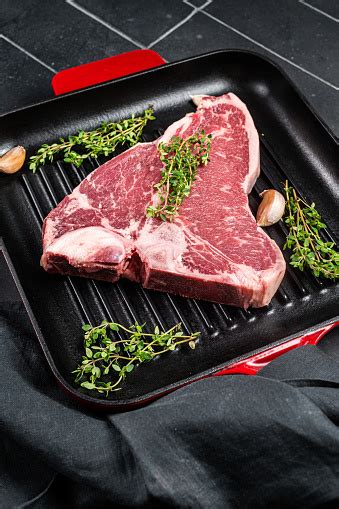 생 티본 또는 포터하우스 쇠고기 고기 요리 준비가 된 그릴 프라이팬에 백리향을 곁들인 스테이크 검은 배경입니다 상위 뷰 0명에