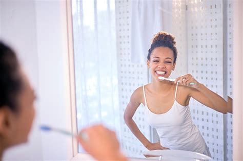 여자 양치질과 칫솔 치아와 깨끗한 입 신선한 호흡과 아침 일과를 닦으면서 미소 위생 건강 및 미용 청소 구강 관리 및 손질로 거울 반사 20 24세에 대한 스톡 사진 및