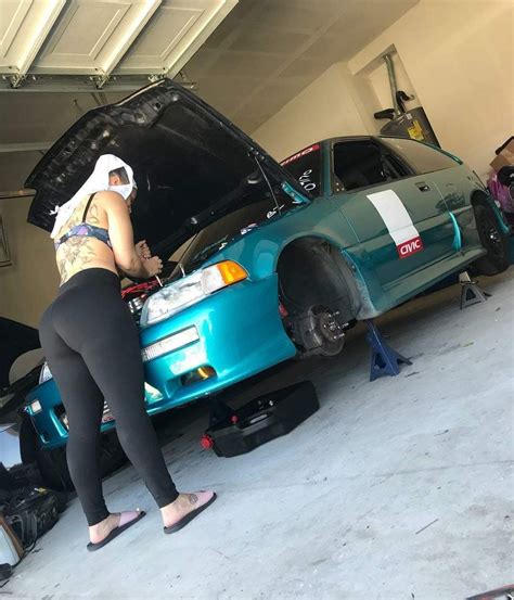 A Woman Working On A Car In A Garage