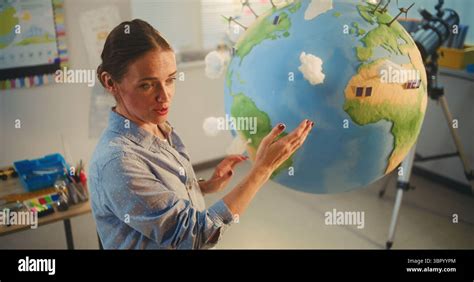 Stem Class Female School Teacher Educating Science And Renewable Energy Sources Using Model Of