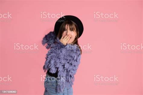 검은 모자를 쓴 젊고 아름다운 검은 머리의 여성이 놀랍게도 손으로 입을 덮었다 스튜디오의 분홍색 배경에 20 24세에 대한 스톡 사진 및 기타 이미지 Istock