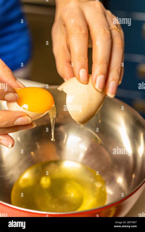 Woman S Hands Separating Egg Yolk From Whites Stock Photo Alamy
