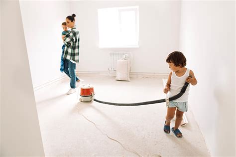 개조 된 방에서 건설 진공 청소기를 가진 작은 귀여운 소년과 그의 어머니와 형제 행복한 가족이 새 집을 수리하고 있습니다 아기에 대한 스톡 사진 및 기타 이미지 Istock