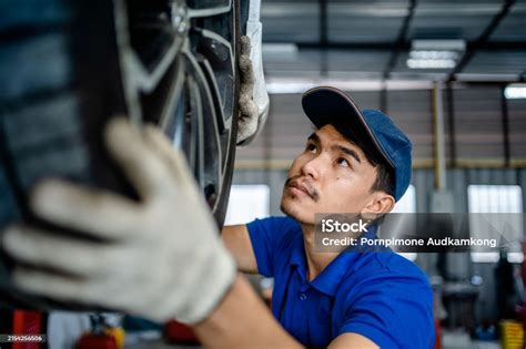 자동차 정비사 수리공은 차고에서 타이어 상태와 서스펜션을 점검하고 예비 부품을 교체하고 자동차의 주행 거리를 확인하고 점검 및