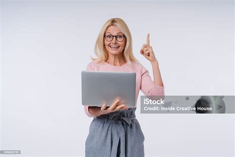 회색 배경위에 고립 된 복사 공간을 가리키는 노트북을 가진 똑똑한 노인 백인 여성 노트북에 대한 스톡 사진 및 기타 이미지 노트북 가리키기 사람들 Istock