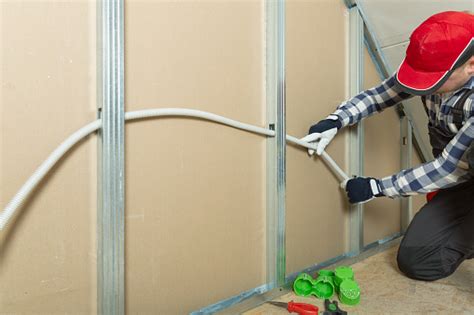 직장에서 전기다락방에서 석고 보드 벽에 전기 와이어를 설치 전기 연료 및 전력 생산에 대한 스톡 사진 및 기타 이미지 전기 연료 및 전력 생산 집 확장 설치미술