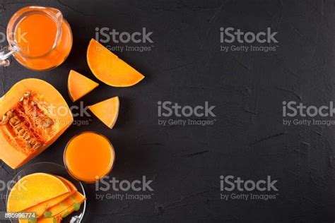 아름 다운 안경 및 갈색 나무 배경에 익은 야채 조각으로 용기에 호박 신선한 주스 달콤한 오렌지 주스입니다 건강 한 식사 다이어트 테마입니다 사진을 닫습니다 가로 배너 0