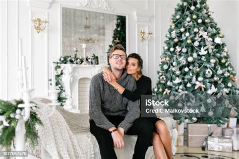 젊은 커플 행복 한 가족 집에서 재미입니다 밝은 거실에 크리스마스 아침입니다 새해 복 많이 받으세요 장식 된 크리스마스 트리 12월에 대한 스톡 사진 및 기타 이미지