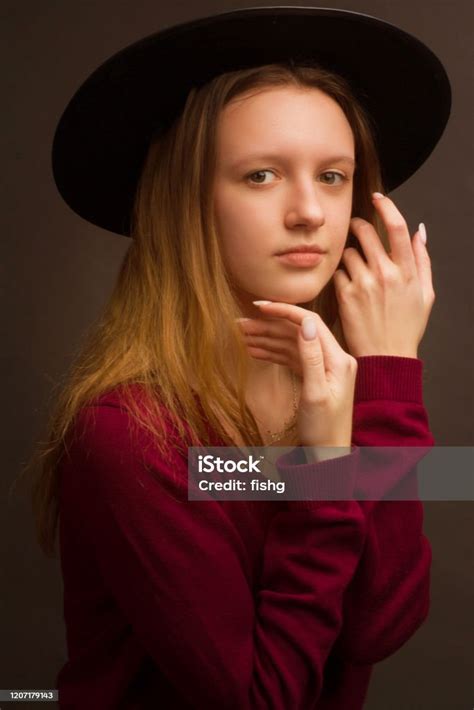 빨간 스웨터에 그려진 금발 머리와 스튜디오에서 여자의 초상화 블랙 와이드 챙 모자에 만짐에 대한 스톡 사진 및 기타 이미지