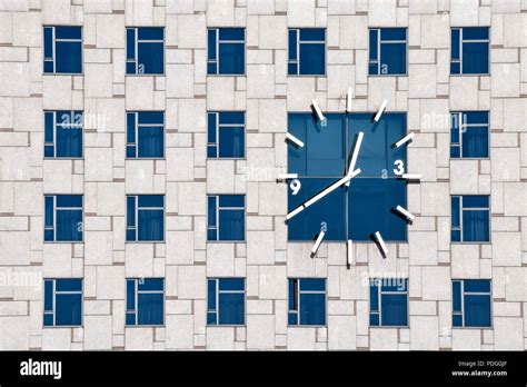 Clock On A Contemporary Building Facade With Multiple Identical Windows Stock Photo Alamy