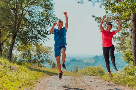 아름다운 햇볕이 잘 드는 숲 운동 및 피트니스 컨셉을 통해 시골 길에서 조깅하면서 건강한 라이프스타일을 즐기는 커플 20 24