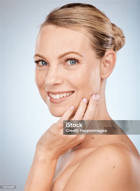 아름다움 스킨케어 및 천연 화장품 건강한 피부 및 화장품 피부과를 위한 얼굴에 손을 가진 여성 행복한 웰빙 모델 유기적인 얼굴 빛 회색 스튜디오 배경에 미소를 짓는 초상화