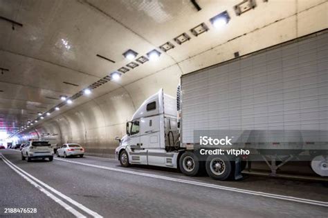 보닛 큰 장비 흰색 세미 트럭 냉장고 세미 트레일러에서화물을 운송하는 편도 멀티 라인 터널에서 실행 0명에 대한 스톡 사진 및