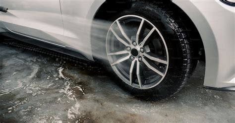 손으로 세차 자동차 세부 사항 물총으로 자동차 바퀴를 청소하는 과정의 이미지를 닫습니다 자동차 림은 고압수를 사용하여 세척합니다 수동 휠 청소 개념의 세부 사항 사진