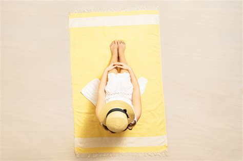 밀짚 모자를 쓰고 노란 비치 타월에 다리를 껴안고 있는 드레스를 입은 슬픈 여성 공중 보기 공중 뷰에 대한 스톡 사진 및 기타 이미지 Istock