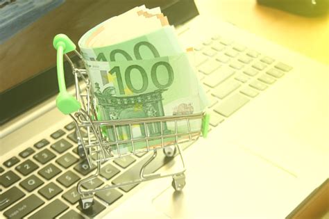 온라인 쇼핑 저축 사업 및 돈을 버는 뿐만 아니라 사업을 운영하기위한 개념으로 종이 유로 지폐와 노트북에 미니 더미 쇼핑 카트 개념에 대한 스톡 사진 및 기타 이미지