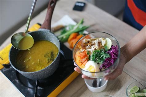 Premium Photo Hands Adding Soup Into Bowl For Making Chicken Soup