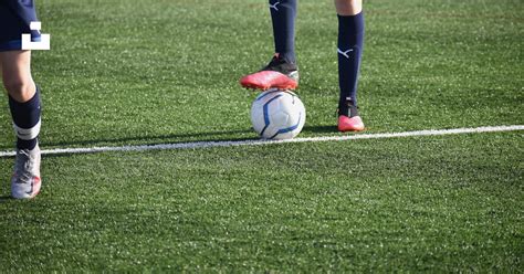 흑인과 백인 축구 유니폼을 입은 사람이 낮 동안 푸른 잔디밭에서 축구공을 차고 있다 사진 Unsplash의 무료 축구 공 이미지