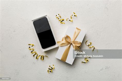 골드 리본과 스마트폰이 있는 기프트 박스를 컬러 배경 상단 보기로 오픈했습니다 빈 오픈 박스 포장 모형 디자인템플릿 브랜딩 모형