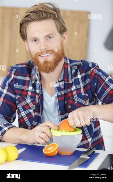 a man squeezes orange juice Stock Photo - Alamy