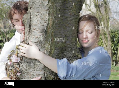 Couple Hugging Tree In Park Stock Photo Alamy