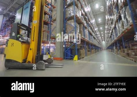 Worker On A Modern Forklift Working In A Large Modern Warehouse