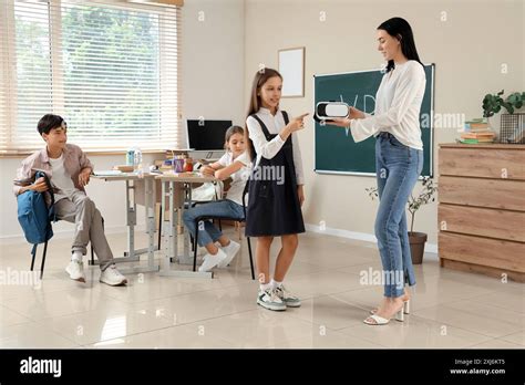 Female Teacher Showing Vr Glasses To Pupil In Classroom Stock Photo Alamy
