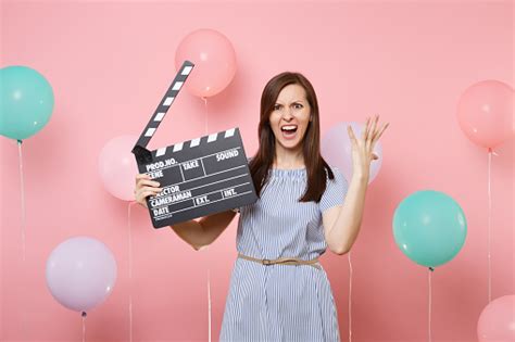 손에 들고 화려한 공기 Baloons와 분홍색 배경에 Clapperboard 만드는 고전적인 흑인 영화를 확산 하는 파란 드레스에 염증된 여자의 초상화 생일 휴가 파티
