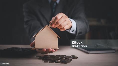 저축과 투자를 상징하는 목조 주택 모델에 동전을 놓는 손 재무 계획 부동산 모기지 은행 업무에 이상적입니다 경제 성장과 안전한 투자의 개념 가격에 대한 스톡 사진 및 기타