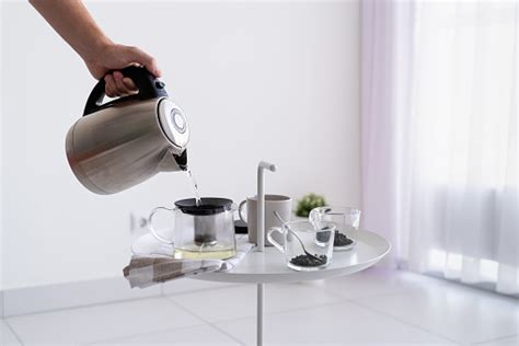 커피 테이블과 남자 손 주전자를 들고 차를 만들기위한 뜨거운 물을 붓는 가정 생활에 대한 스톡 사진 및 기타 이미지 가정