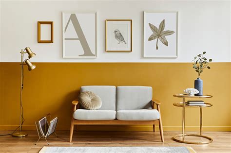 디자인 소파 우아한 골드 커피 테이블 모의 포스터 프레임 꽃병꽃 장식 및 홈 장식페스로나 액세서리가 있는 현대적인 스타일의 인테리어의 독특한 거실 템플릿 0명에 대한 스톡