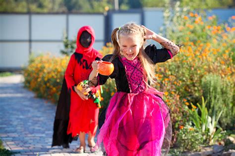 마녀로 옷을 입은 소녀가 집행자로 옷을 입은 소년에게서 도망치고 있다 할로윈에 캐치 업을 재생 하는 어린이 10월에 대한 스톡 사진 및 기타 이미지 Istock