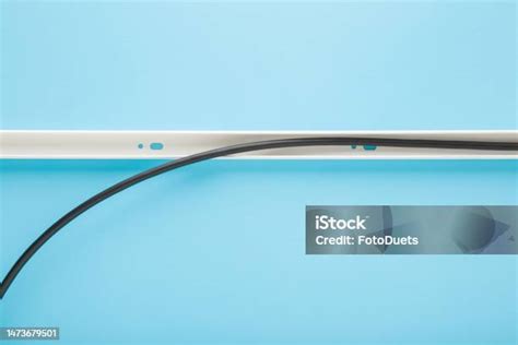 밝은 파란색 테이블 배경에 흰색 플라스틱 채널의 어두운 검은색 새 와이어 파스텔 색상 근접 촬영 배선 설치 하향식 보기 0명에