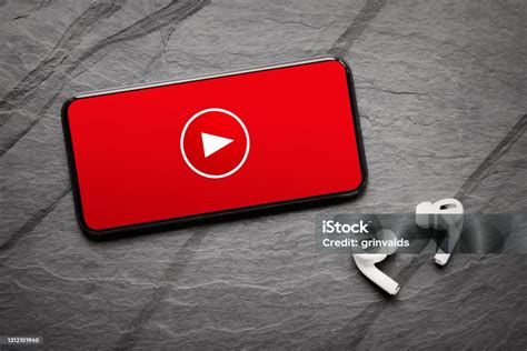 어두운 배경에 휴대 전화의 화면과 무선 이어폰에 비디오 플레이어 응용 프로그램 텔레비전에 대한 스톡 사진 및 기타 이미지 텔레비전 무선 인이어 헤드폰 지켜 봄