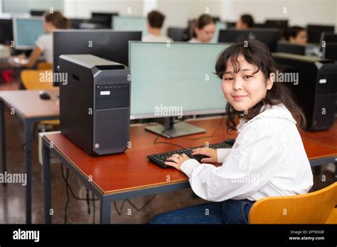 Smart Asian Female Teenager Learning Computer Science While She Is Using A Pc In The Computer