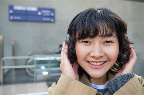 Close Up Portrait Of Stylish Korean Girl Standing On Street Listening