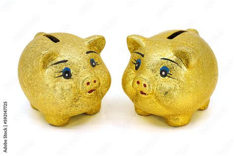 Stockfoto 흰색 배경에 살짝 위에서 바라본 금색 돼지 저금통 두개 Adobe Stock