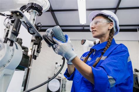 Female Technician Engineer Using Remote Control Automation Robotics At Industrial Modern Factory