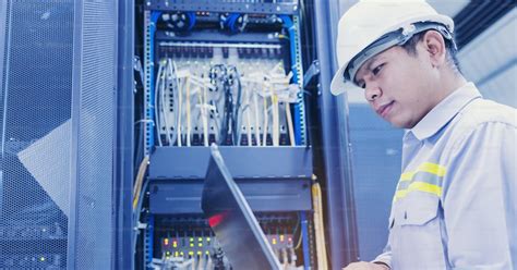 노트북을 든 남자가 데이터 센터의 서버실에 앉아 있습니다 시스템 관리자는 서버가 있는 랙 근처에서 작업합니다 사진 Unsplash의 남성 이미지