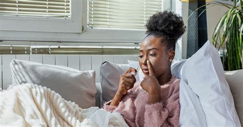 여자는 독감에 걸렸고 그녀는 자신을 돕기 위해 비강 스프레이를 사용하고 있습니다 비강 스프레이를 사용하는 여성 감기에 도움이되는 비강 스프레이 코가 떨어지는 비염으로