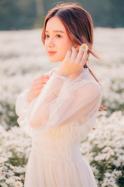 들판 위의 흰 드레스를 입은 젊은 여성 · 무료 스톡 사진