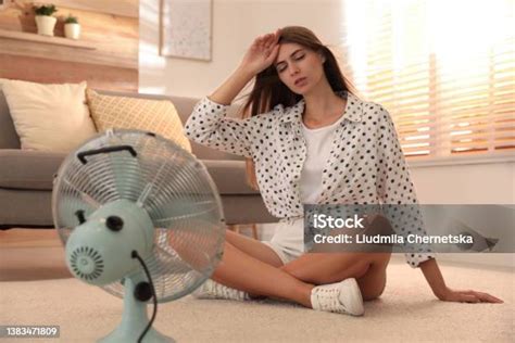 거실에서 바닥에 팬에서 공기 흐름을 즐기는 여자 여름 더위 원기 회복에 대한 스톡 사진 및 기타 이미지 원기 회복 25 29세 거실 Istock
