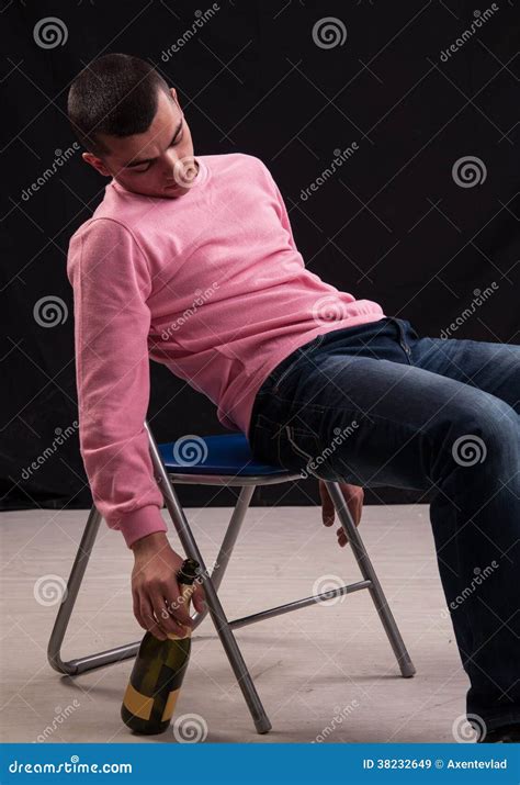 O Homem Novo Que Bebeu O Vinho Caiu Adormecido Na Cadeira Imagem De Stock Imagem De Tristeza
